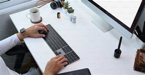 젊은 남자 사진 작가 또는 그래픽 디자이너가 자신의 워크 스테이션에서 컴퓨터로 작업하는 높은 각도보기 사진 Unsplash