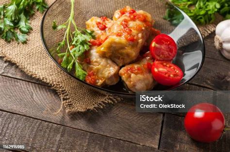 삶은 양배추 롤 의 한 부분 과 토마토 소스 의 쌀과 고기 가득 검은 유리 접시 에 야채 근처 Sacking 과 소박한 나무 테이블 갈색에 대한 스톡 사진 및 기타 이미지