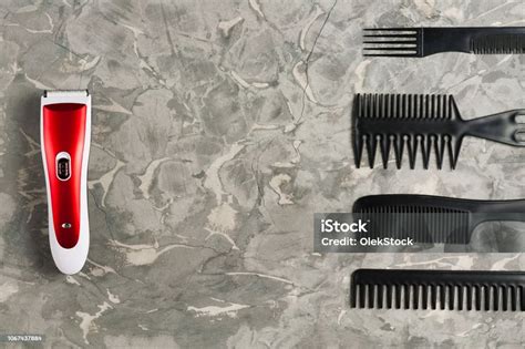 하나의 빨간색과 흰색 전문 깎기 그리고 오래 된 회색 콘크리트 표면에 검은 플라스틱 빗의 행 최고 보기 및 복사 공간 개인