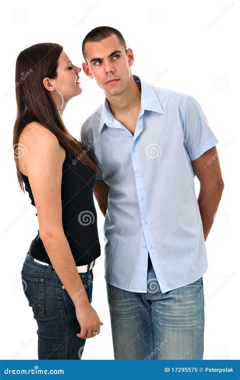 La Muchacha Susurra En El Oído De Su Novio Aislado Imagen De Archivo