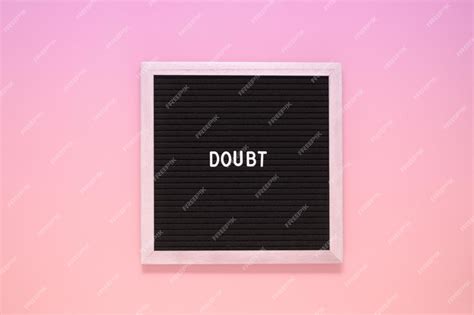 검정 펠트 보드 배경에 있는 단어 의심의 흰색 문자 프리미엄 사진