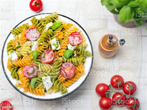 이탈리아 요리화려한 파스타 체리 토마토 Feta 치즈와 흰색 나무 바탕에 신선한 바 질 샐러드 건강한 식생활에 대한 스톡 사진