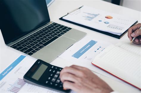 Pebisnis Menganalisis Grafik Investasi Dengan Menggunakan Laptop Dan