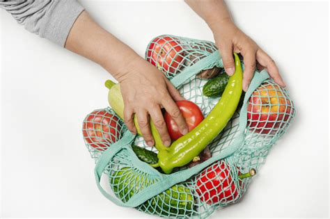 한 여성이 야채와 과일을 재사용 가능한 파란색 메쉬 가방에 넣습니다 면 쇼핑백 폐기물 제로 가냘픈에 대한 스톡 사진 및 기타 이미지 Istock