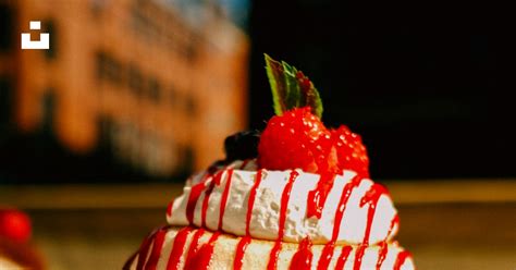 휘핑크림과 딸기로 덮인 디저트를 얹은 하얀 접시 사진 Unsplash의 무료 맨체스터 이미지