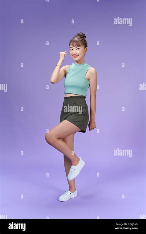 Full Length View Of Blissful Asian Girl Dancing On Purple Background