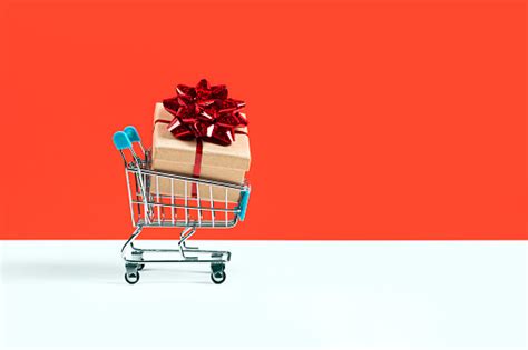 큰 선물 상자 장난감 쇼핑 카트 또는 트롤리 휴일 기념일 또는 생일을 위한 선물입니다 빨간 배경 위에 격리 선물 상자와 트롤리 카트 복사 공간이 있는 배너 0명에 대한 스톡