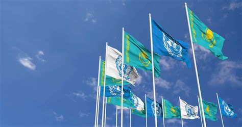Kazakhstan And United Nations Un Flags Waving Together In The Sky