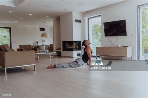 집에서 훈련 노트북에서 온라인 자습서를 보면서 훈련을 하는 스포티한 남자 거실에서 운동 여유 공간 20 24세에 대한 스톡 사진 및 기타 이미지 Istock