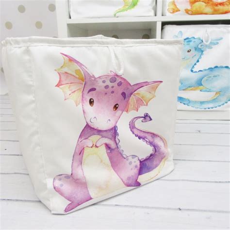 A Pink And Purple Dragon Bag Sitting On Top Of A White Table Next To