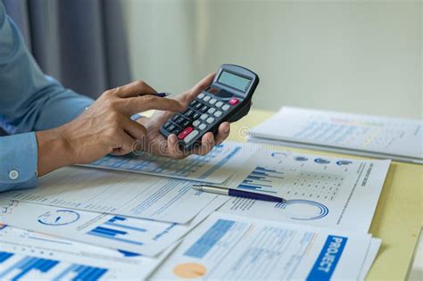 businessman points at graph charts and uses laptop computer for data