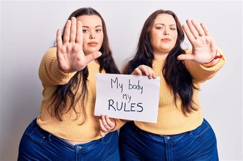 Premium Photo Young Plus Size Twins Holding My Body My Rules Banner With Open Hand Doing Stop