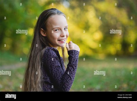 Cute Girl Sucking On A Lollipop Candy Autumn Park In The Background
