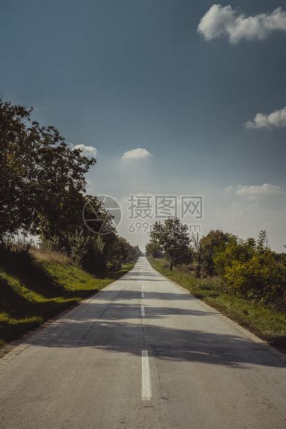 空旷的道路天空中有云两侧有树木高清图片下载 正版图片504952258 摄图网