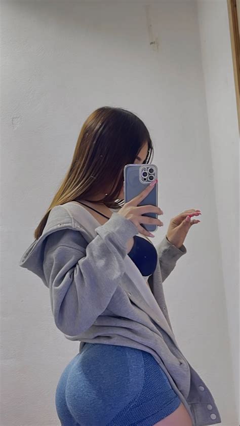 A Woman Taking A Selfie With Her Cell Phone In Front Of The Mirror