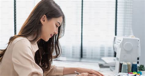 아시아의 아름다운 재단사 여자가 재봉 아틀리에에서 옷을 입고 있다 매력적인 여성 패션 디자이너 양장점 디자인 드로잉 및 워크샵