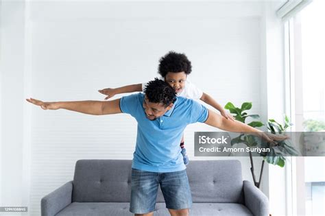 행복한 아프리카계 미국인 아버지 돼지 백 귀여운 곱슬 작은 아들 쾌활한 아프리카 아빠 놀이 재미와 집에서 작은 아들과 함께 시간을 보내고 2 3 살에 대한 스톡 사진 및