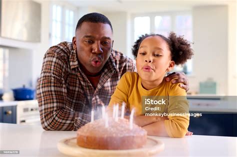 집에서 만든 생일 케이크에 촛불을 불고 축하하는 부엌에서 집에서 아버지와 딸 10 11세에 대한 스톡 사진 및 기타 이미지