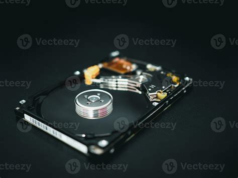 Disassembled Open Hard Disk Drive HDD Of Computer Or Laptop Lies On Dark Matte Surface