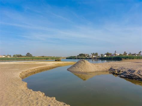 Premium Photo Sand Piles On The Beach In Front Of A River