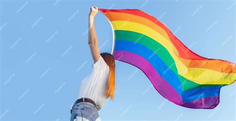 Premium Photo Woman Holding The Lisbian Rainbow Lgbt Flag Over Blue