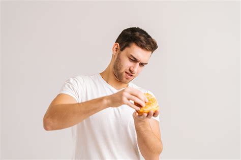 백인 고립 된 배경에 나쁜 햄버거의 꽃봉오리를 따기 혐오와 불만 젊은 남자의 초상화 건강에 좋지 않은 음식에 대한 스톡 사진 및