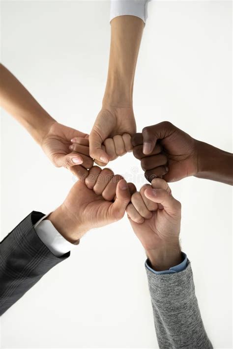 View From Below Of Diverse Colleagues Give Fists Bump Stock Photo