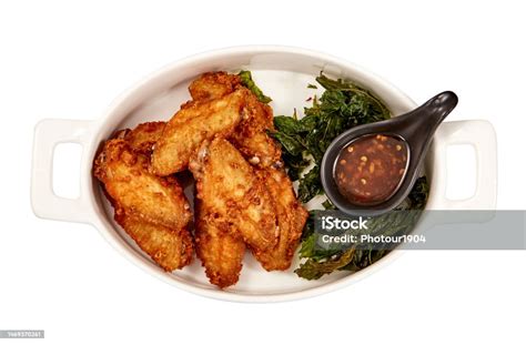 흰색 배경에 격리된 바삭한 바질 잎과 치킨 디핑 소스를 곁들인 바삭한 프라이드 치킨 날개의 상위 뷰 인기있는 전채 고기에 대한