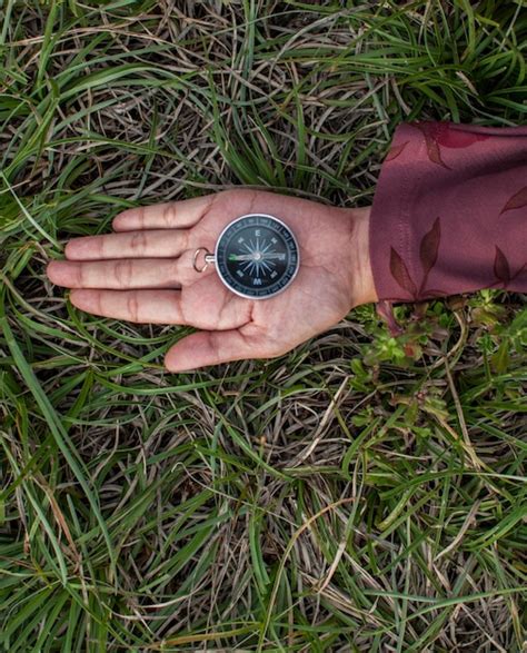 Premium Photo Close Up Of Woman Holding Navigational Compass On Field