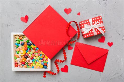 Red Envelope With Candy And T Box And Valentines Hearts On Colored Background Flat Lay Top