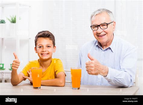 Grandfather And Grandson Are Drinking Orange Juice At Home Healthy Lifestyle Stock Photo Alamy