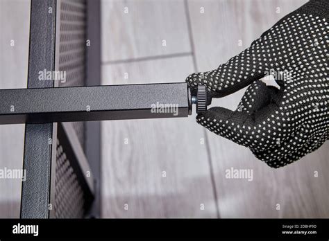 Assembler In Gloves Is Tightening Bolt While Mounting Flat Pack