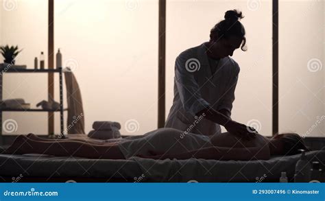 Masseur Massage Specialist Giving Back Massage To His Patient Silhouettes Of A Woman And A Man