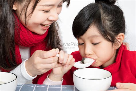 Mamá Alimenta A Su Hija A Comer Bolas De Arroz Foto Descarga