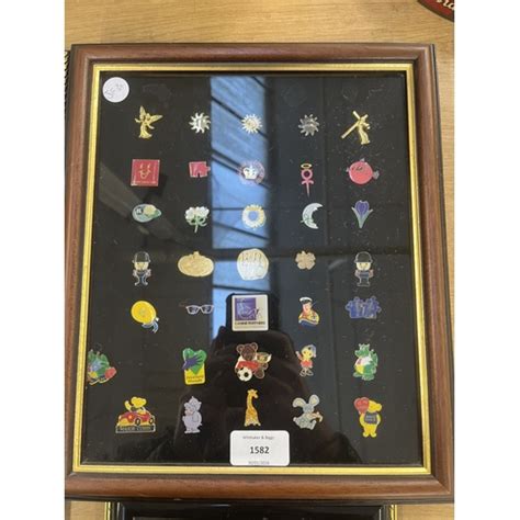 Four Framed Items Containing Novelty Pin Badges
