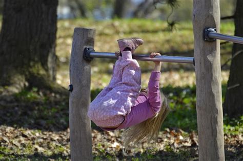 Premium Photo Girl Hanging While Playing At Jungle Gym