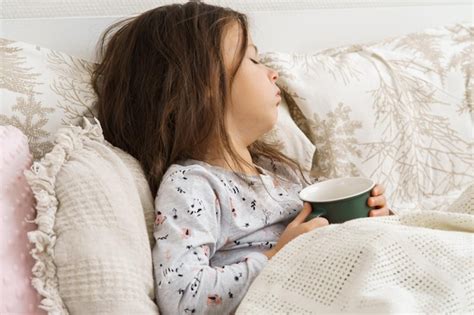Querida Niña De Cabello Oscuro En Edad Preescolar Tosiendo Bebiendo Té