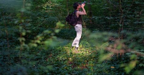 한 여자가 카메라를 들고 숲에 서 있다 사진 Unsplash의 사진술 이미지