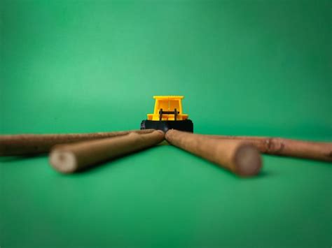 Premium Photo Excavator With Wooden Stick On Green Background