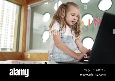 Cute Girl Using Laptop Programing Software While Looking At Camera With