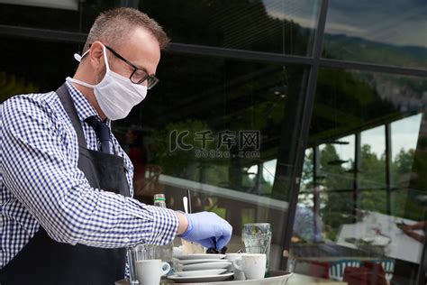 戴着医用防护面具的侍者在餐厅供应咖啡高清摄影大图 千库网