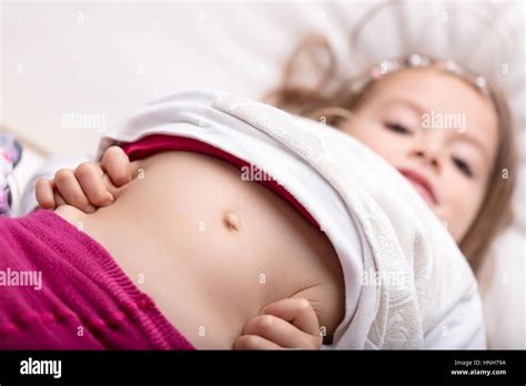 Spaß kleines Mädchen das Fett an den Seiten des nackten Bauch mit den