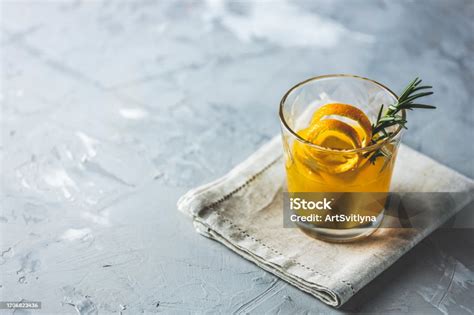 로즈마리 심플 시럽또는 홈메이드 위스키 사워 칵테일 음료와 오렌지 로즈마리 장식 오렌지 껍질을 린넨 냅킨에 곁들인 허니 버번 칵테일 한 잔 각얼음에 대한 스톡 사진 및 기타