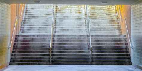 Wide Flight Of Stairs At A Passageway Under A Building With Brick Wall