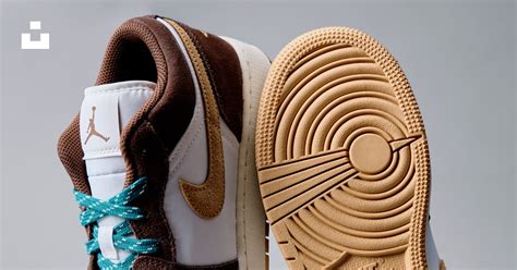 파란색 끈이 달린 갈색과 흰색 운동화 한 켤레 사진 Unsplash의 무료 구두 이미지