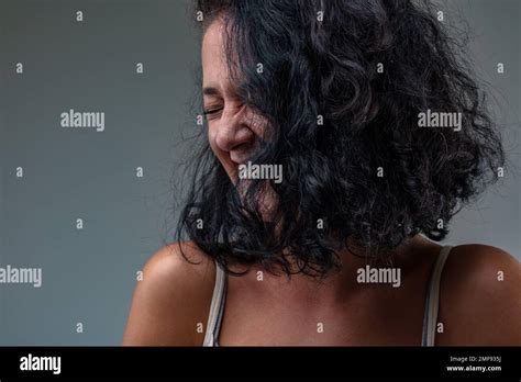 Frontal Portrait Of A Young Brunette Girl In A Tank Top Laughing Or