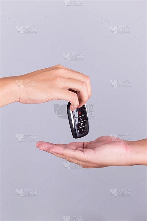 人的手把汽车遥控器交给另一只手