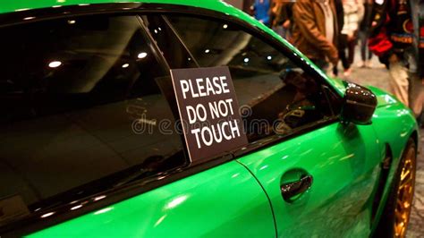 Please Do Not Touch Sign On A Luxury Green Sports Car With Warning Message For Stock Image
