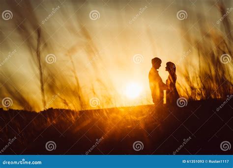 A Romantic Silhouette Of A Man And Woman Hugging And Kissing Stock