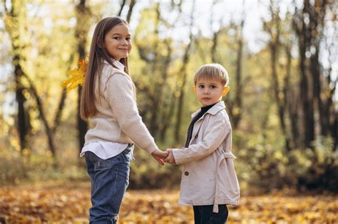 Hermano con hermana juntos en el parque de otoño Foto Premium